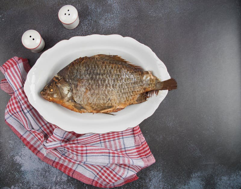 Grilled Fish Carp on a White Plate Against a Dark Background. Copy ...