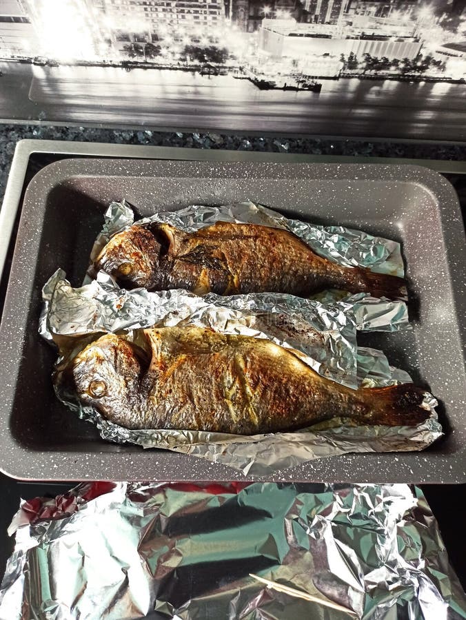 Grilled Fish Resting on Aluminum Foil in a Kitchen Setting Showcasing ...