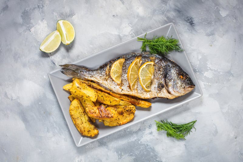 Grilled Fish on Stone Plate with Lemon on Concrete Background Stock ...