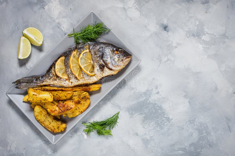 Grilled Fish on Stone Plate with Lemon on Concrete Background, Top View ...