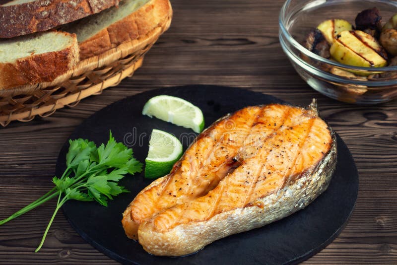 Grilled Salmon Steak on a Black Slate Dish with Parsley and Lime Stock ...