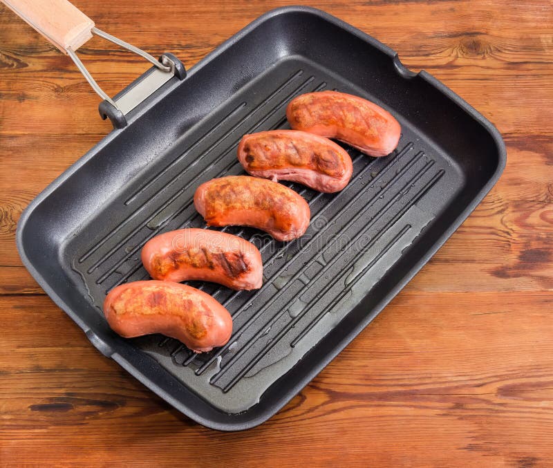 Grilled Sausages on Rectangular Grill Pan on Rustic Table Stock Image ...