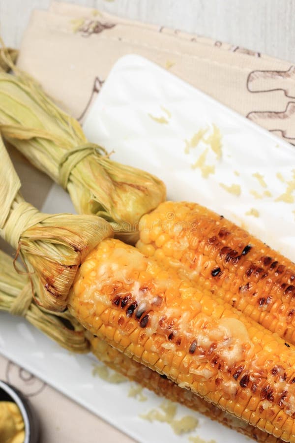Grilled Corn with Butter and Shredded Mozarella. Served on White Plate ...