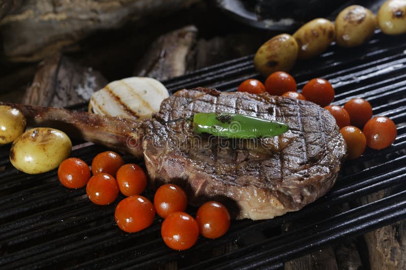 Grilled Tomahawk Steak with Roasted Potatoes and Cherry Tomatoes Stock ...