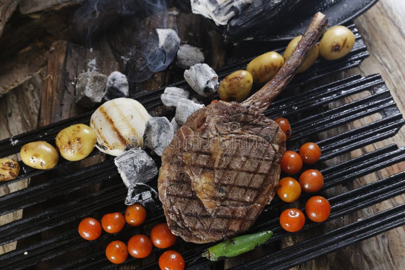 Grilled Tomahawk Steak with Roasted Potatoes and Cherry Tomatoes Stock ...