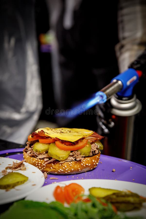 Grilling Cheese with a Gas Burner. the Chef Makes an American Burger ...