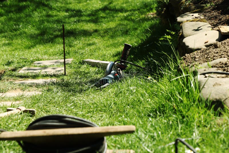 A Grinder in Grass with Extension Cable for Work Stock Image - Image of ...