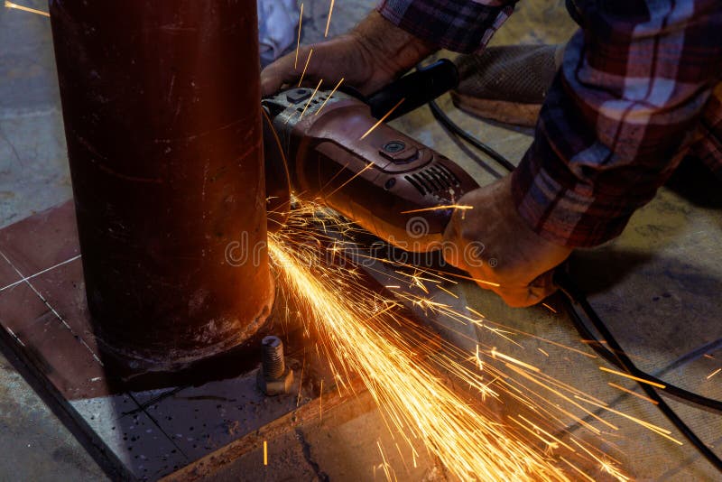 While Grinding Iron, a Worker Cuts Metal with an Abrasive Disk Sparks ...