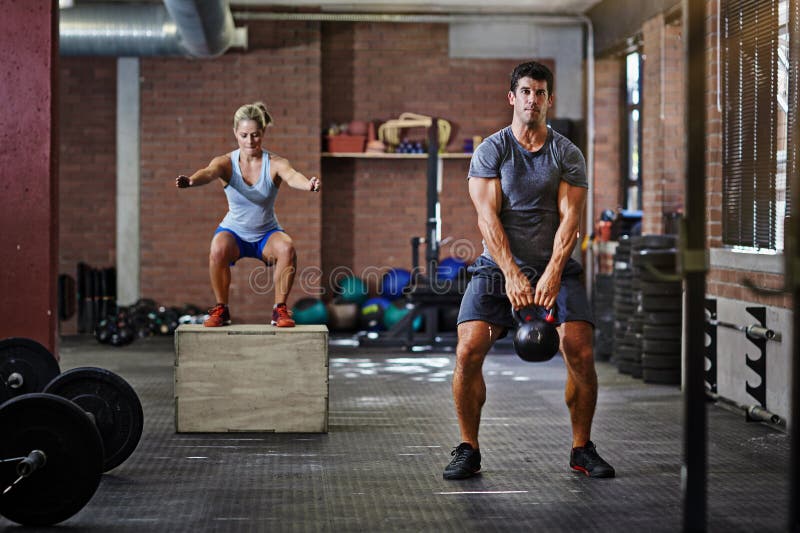 Grip this Workout and Rip it. Two People Working Out with Kettlebells ...