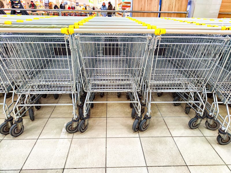Grocery Baskets on Wheels in the Store. Row of Metal Shopping Baskets ...