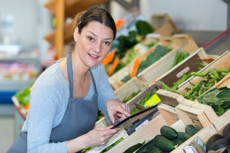 Grocery Store Worker with Surprised Expression Using Tablet Stock Image ...