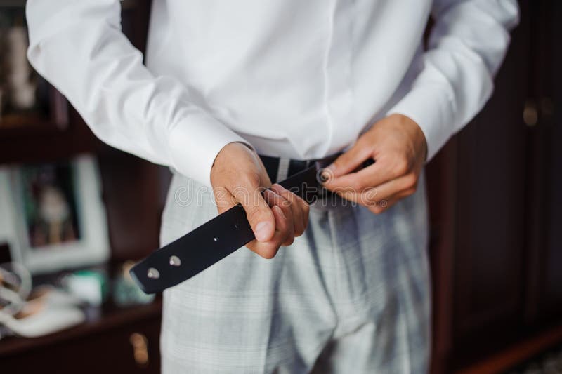Groom Adjusting His Belt while Dressing for Wedding Ceremony Stock ...