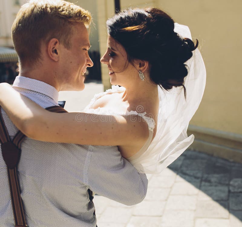Groom Carries Bride in His Arms Stock Photo - Image of beautiful ...