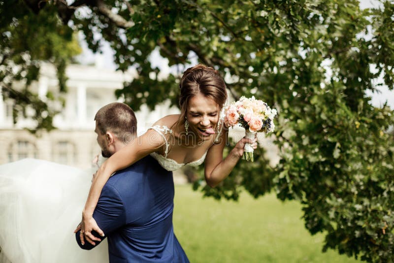 Groom Carries His Bride Over Shoulder Stock Photo - Image of outside ...
