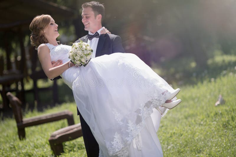 Groom Carrying Bride Outdoors Stock Photo - Image of happiness, married ...