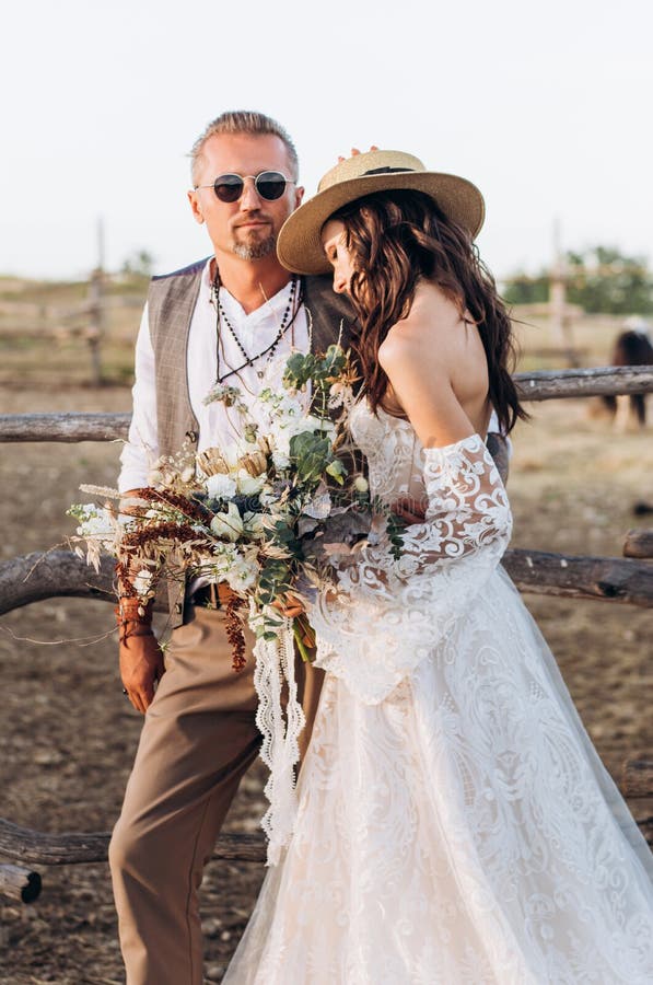 The Groom Dressed in the Style of Boho Gently Kisses the Bride. Stock ...