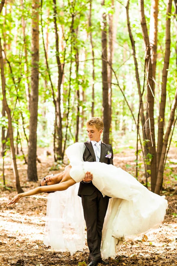 Groom Holding Bride in Dance Pose on Wedding Day Stock Photo - Image of ...