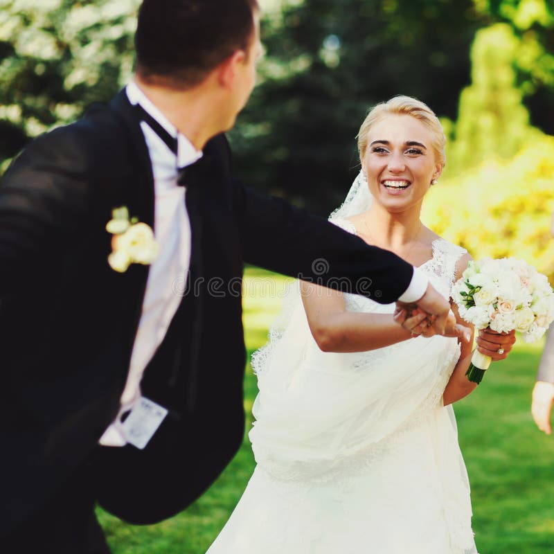 Groom Holds Bride S Hand while they Run Across the Park Stock Photo ...