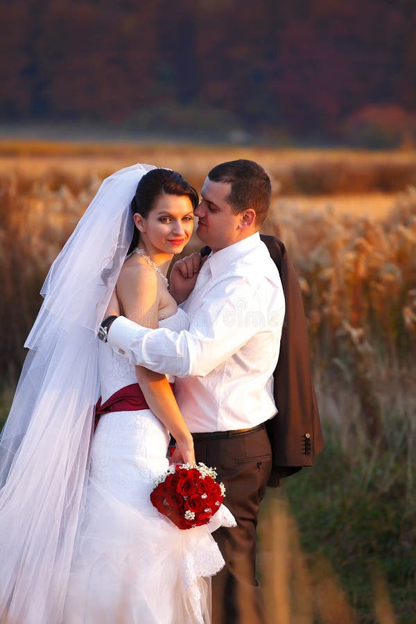 Groom Hugs a Smiling Bride Holding a Jacket Over His Shoulder Stock ...