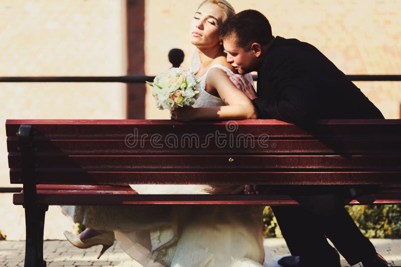 Groom Kisses Bride S Shoulder while they Rest in the Sunrays on Stock ...