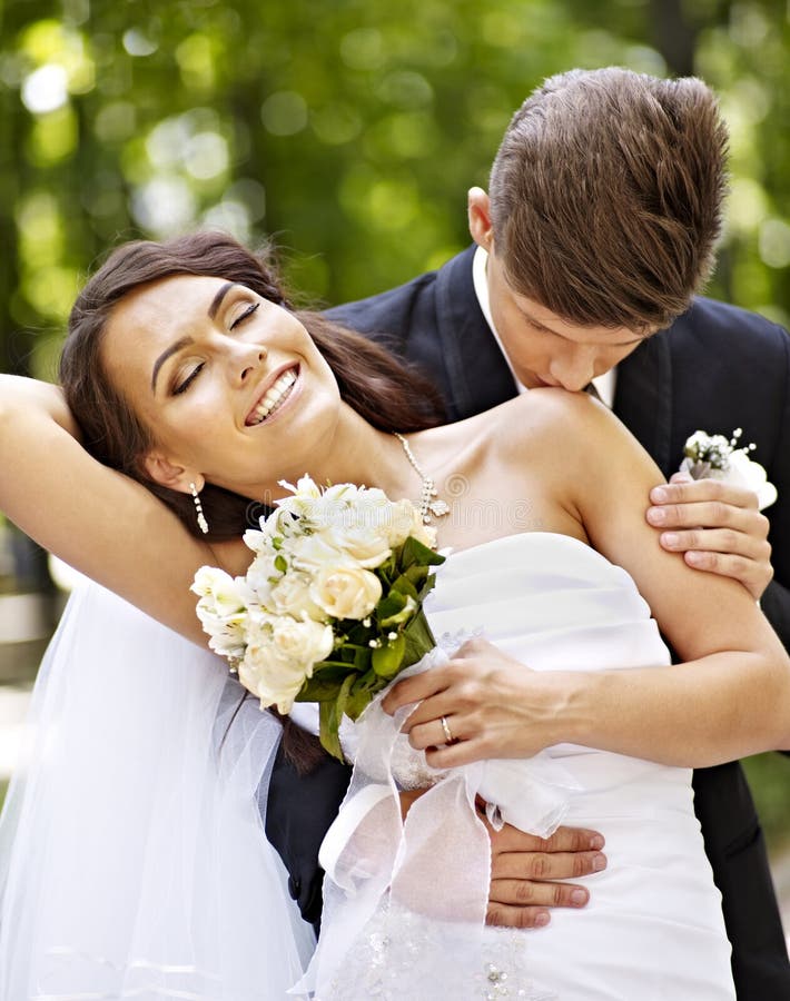 Groom Kissing Bride on Shoulder . Stock Photo - Image of flower ...