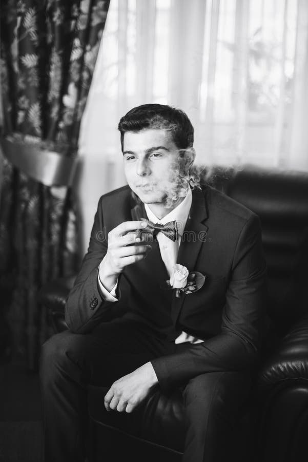 The Groom in a Suit Smoking Cigar Stock Photo - Image of chair ...