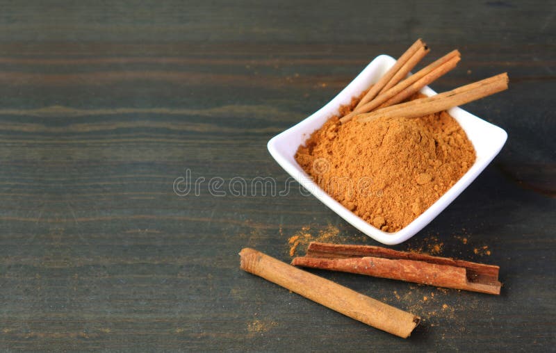 Ground Cinnamon Powder with Cinnamon Sticks on Wooden Background Stock ...