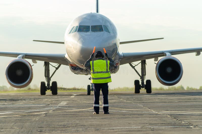 Ground Crew Signaling To Airplane on Wet Runway Stock Image - Image of ...
