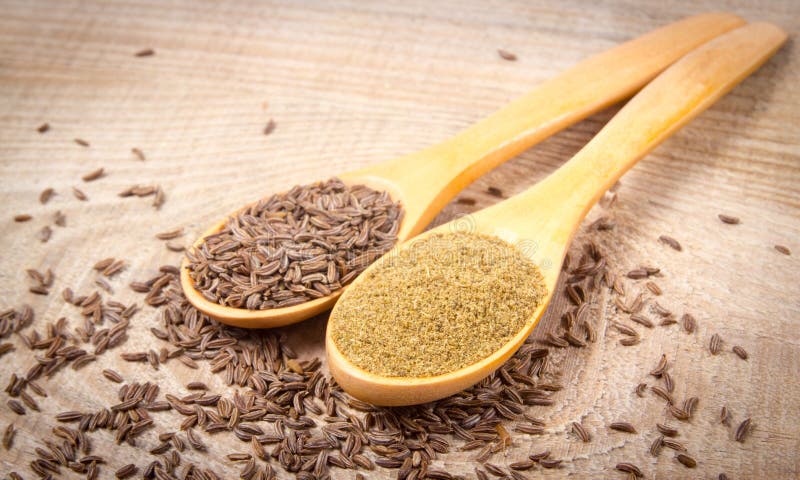 Ground Cumin In A Spoon And Whole Cumin On The Wooden Background. Stock ...