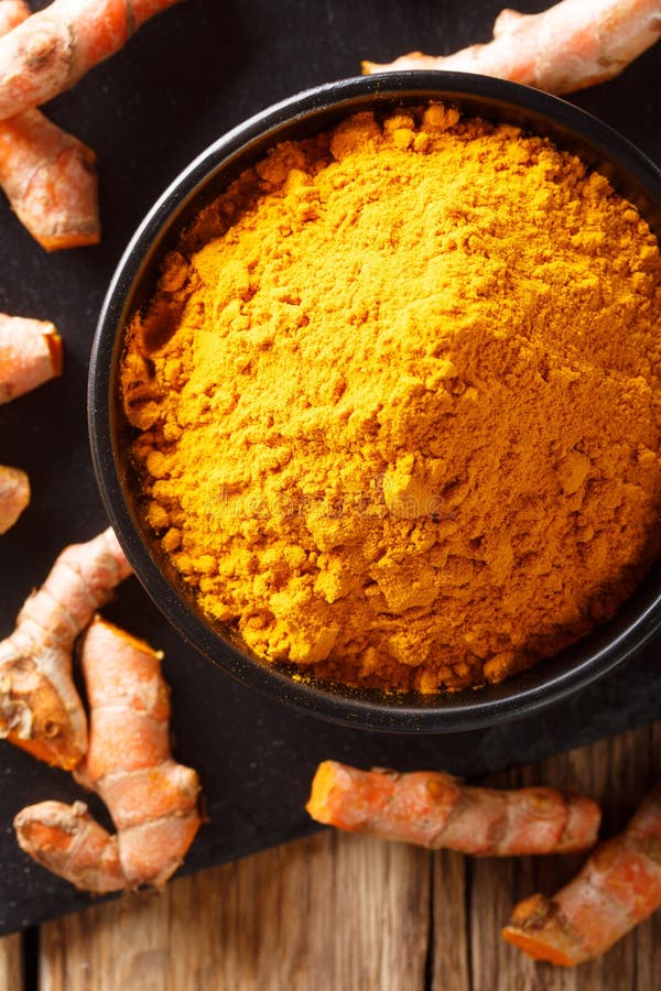 Ground Fresh Turmeric in a Bowl and Root Close-up. Vertical Stock Image ...