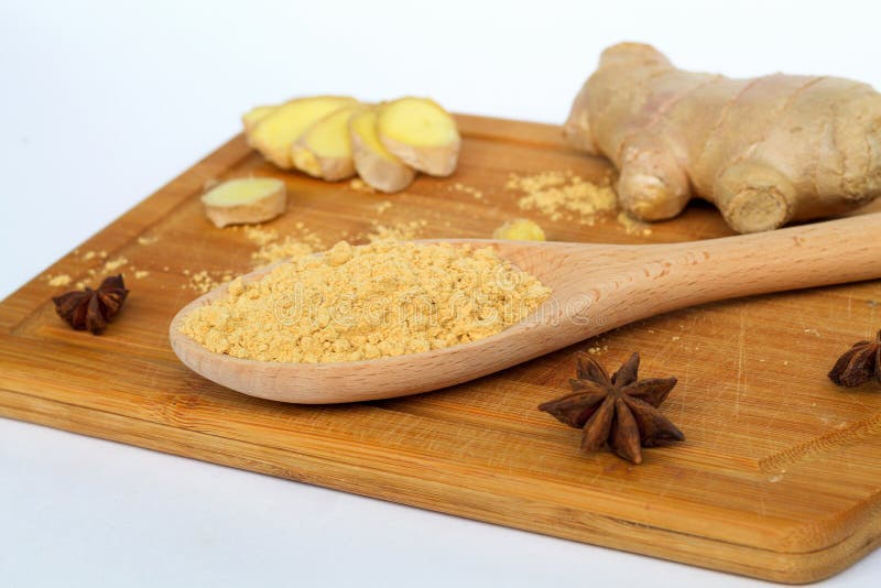Ground Ginger in a Spoon and Slices of Ginger on a Wooden Board Stock ...