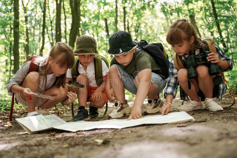 On the Ground with Map. Kids in Forest at Summer Daytime Together Stock ...