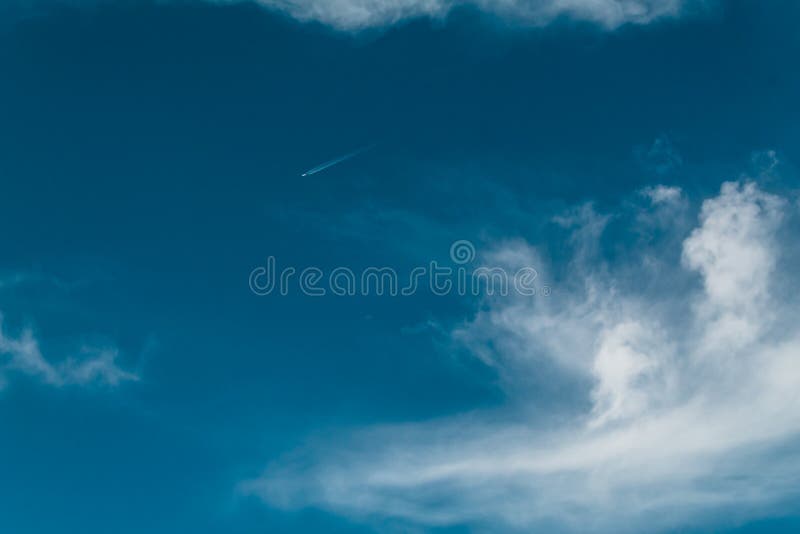 Ground View of an Airplane Against Thick Clouds and Blue Sky Looking Up ...
