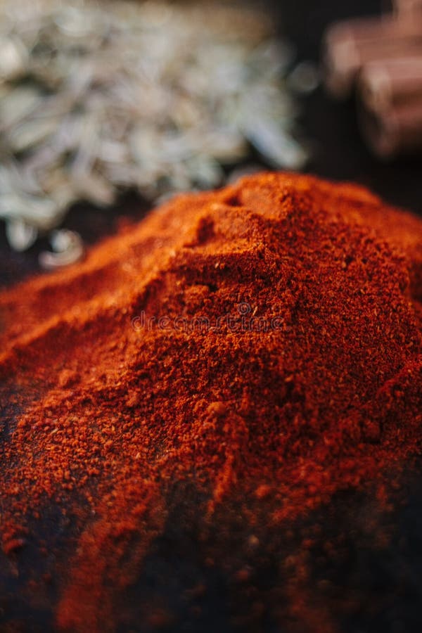 Grounded Chili Pepper on Black Rustic Surface, Surrounded by Spices ...