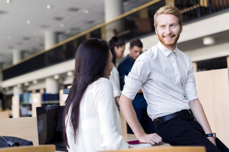 A Group of Academics Studying in the Library and Conversing Stock Image ...