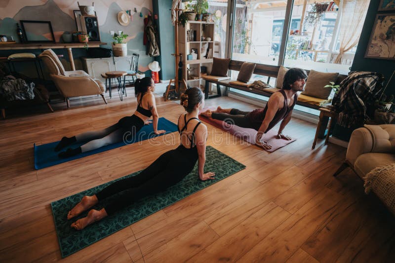 Group of Adults Practicing Yoga Poses on Mats in a Cozy Interior ...
