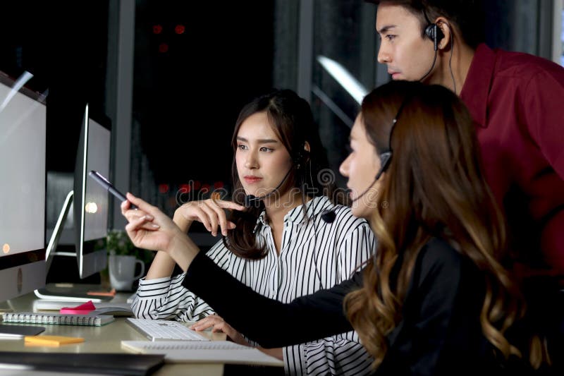 Group of Asian Night Shift Staffs with Headphone Look at Desktop ...