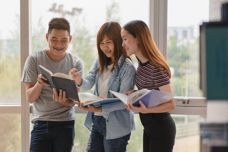 Group of Asian Students Researching Data for Homework Assignment in ...