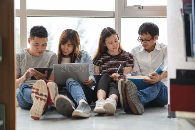 Group of Asian Students Researching Data for Homework Assignment in ...