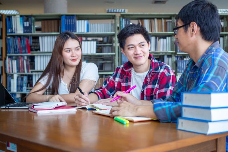 A Group of Asian Students Sitting and Discussing Read Books Together ...