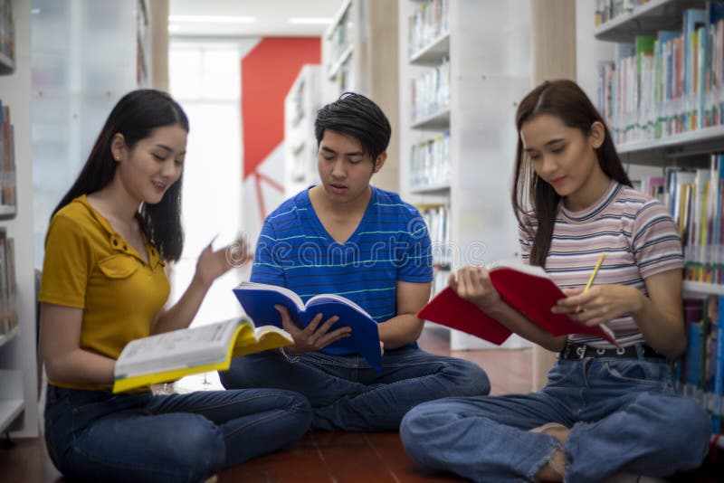 Group Asian Students Smile and Reading a Book and Using the Laptop for ...