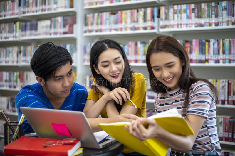 Group Asian Students Smile and Reading a Book and Using the Laptop for ...