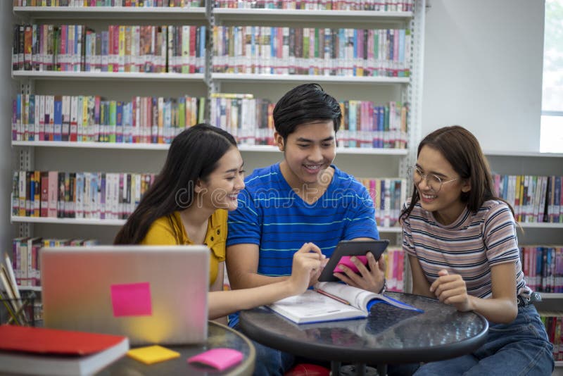 Group Asian Students Smile and Reading a Book and Using the Laptop for ...