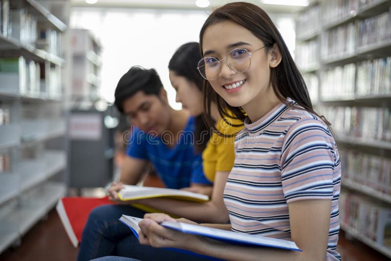 Group Asian Students Smile and Reading a Book and Using the Laptop for ...