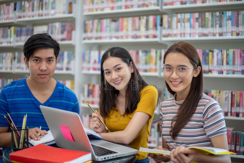 Group Asian Students Smile and Reading Book and Using Notebook for Helps To Share Ideas in the ...