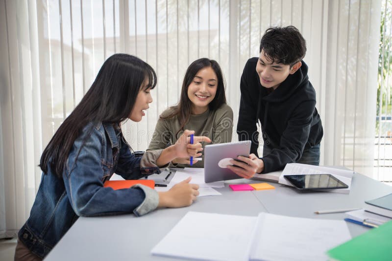 Group Asian Students Smile and Reading Book and Using Notebook for ...
