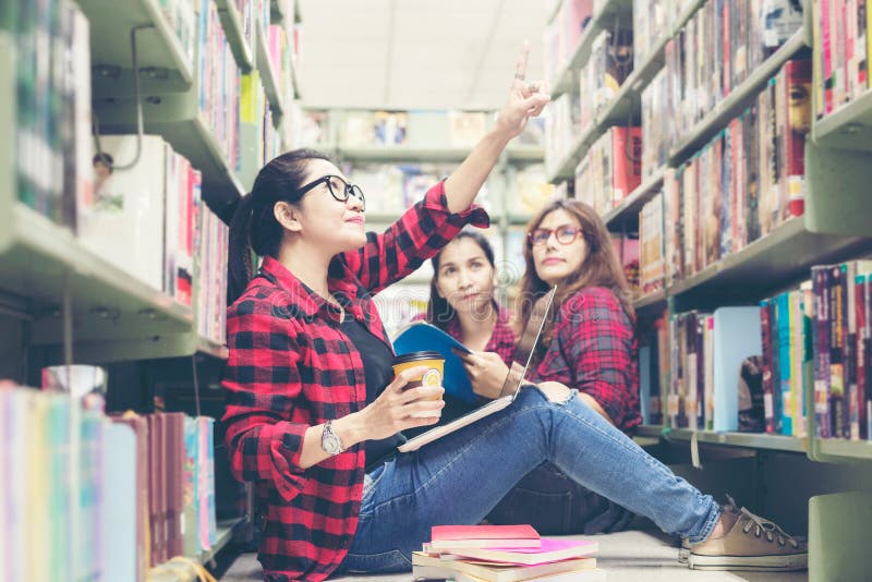 Group Asian Women in Library Reading Something in a Book and Choosing a ...
