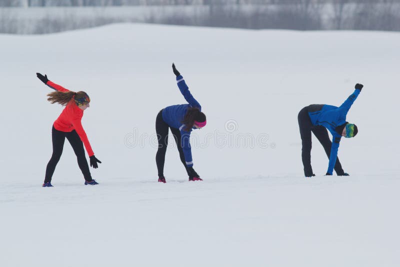 Group of Athletes Doing the Exercise in Winter Field Stock Photo ...