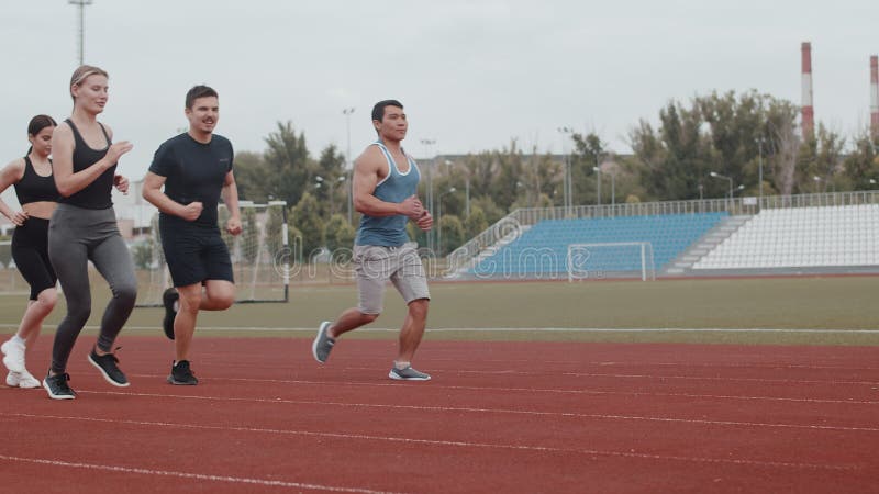 Group of Athletes is Running Around Stadium on the Street, Training and ...
