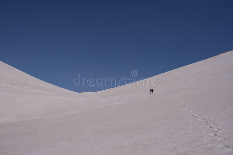 Group of Backpackers Going through the Ravine between Two Snow-covered ...